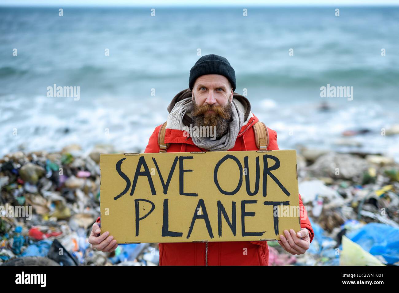 Activist holding placard, protest sign, standing on landfill, large ...