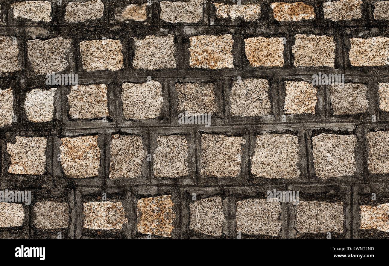 Stone wall textured background. Dark brown and beige bricks have textured and uneven shapes ...