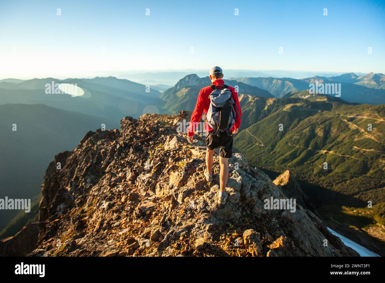 Rear view of backpacker approaching mountain summit Stock Photo - Alamy