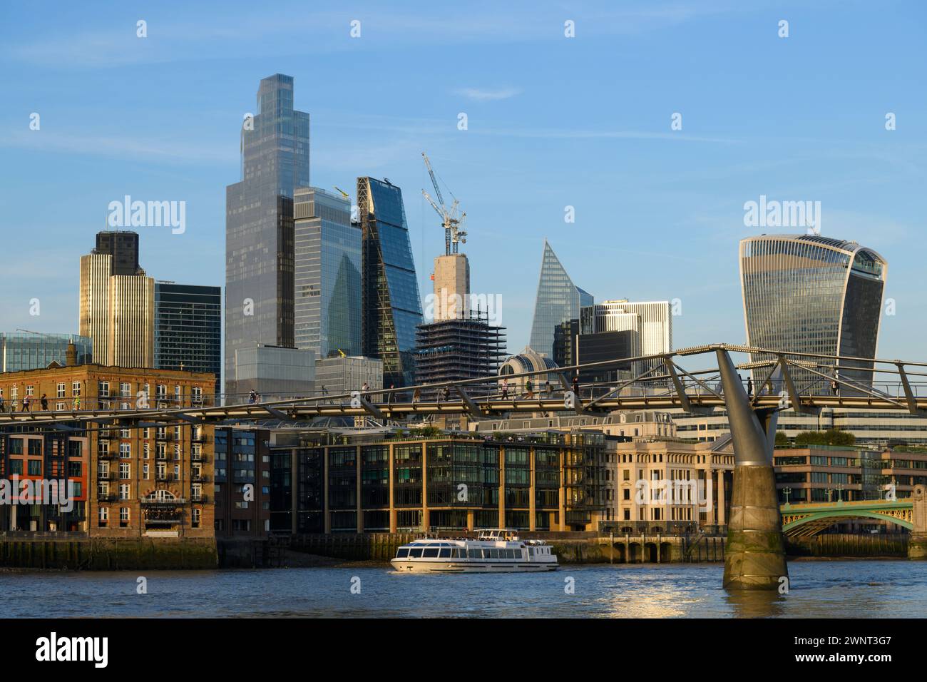 The Millennium footbridge over the River Thames with the skyscrapers of ...