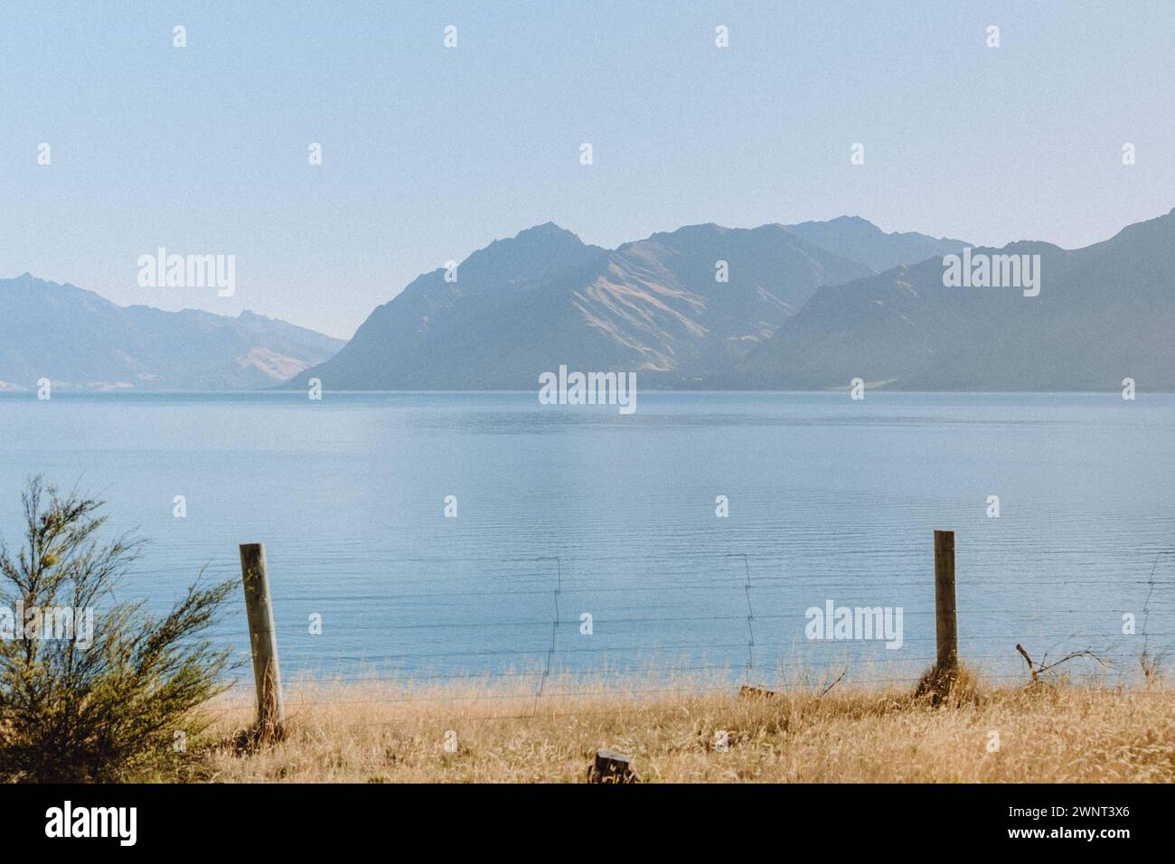Fence line walking trail around Lake Hawea blue water and mountains ...