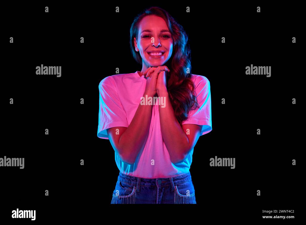 Happy and excited young woman in smiling, clapping hands against black ...
