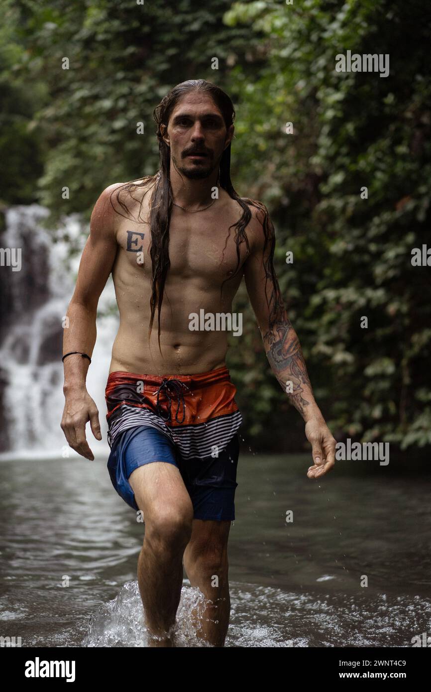 Young handsome man comes out of the water Aling-Aling. Bali Stock Photo ...