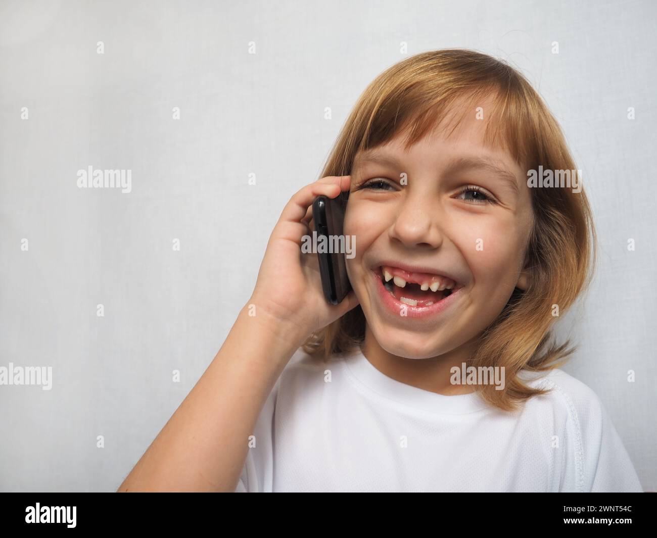 7-year-old girl with no front tooth. The child is talking on the phone ...
