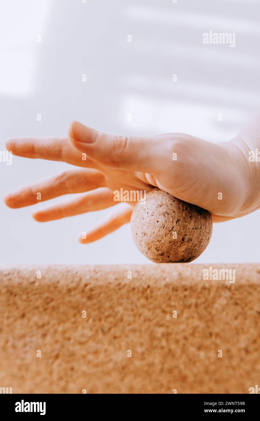 Close up of hand doing palm fascia release exercise with cork ball ...