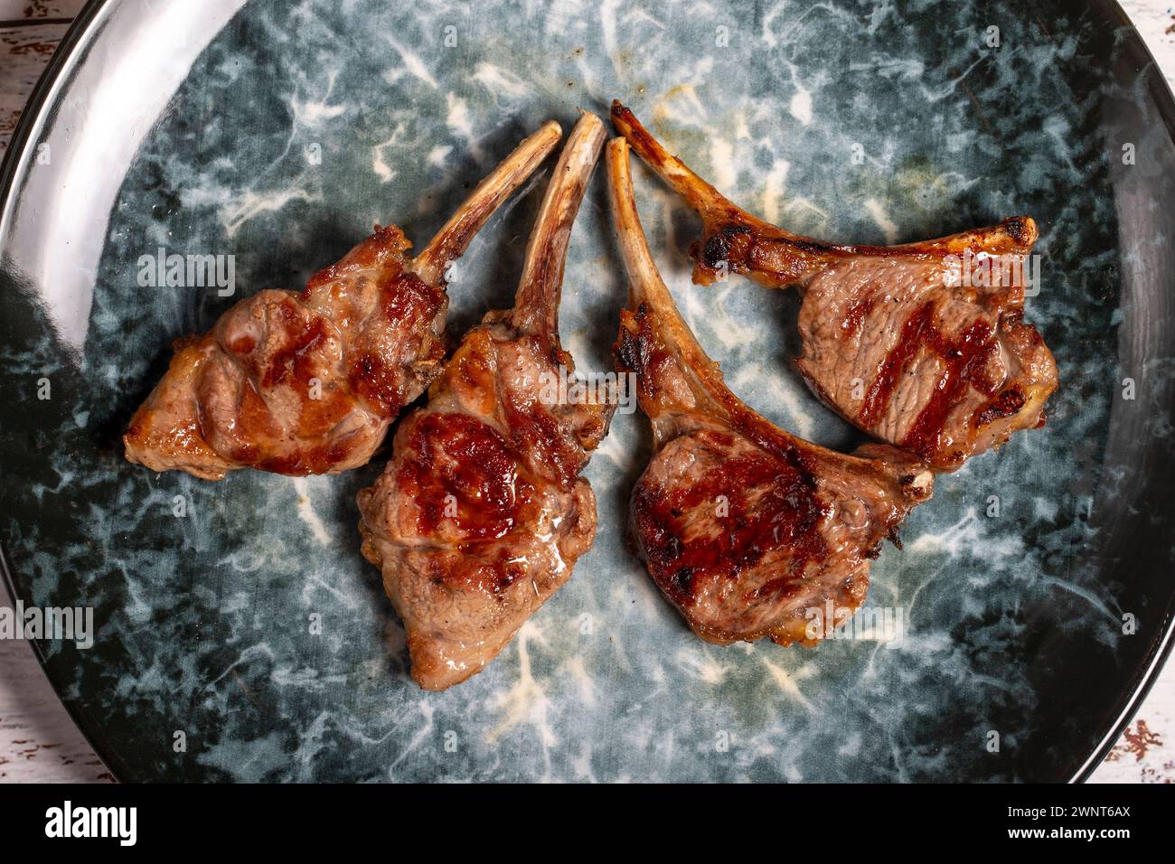 Freshly grilled lamb chops. Slices of cooked lamb chops on wood ...