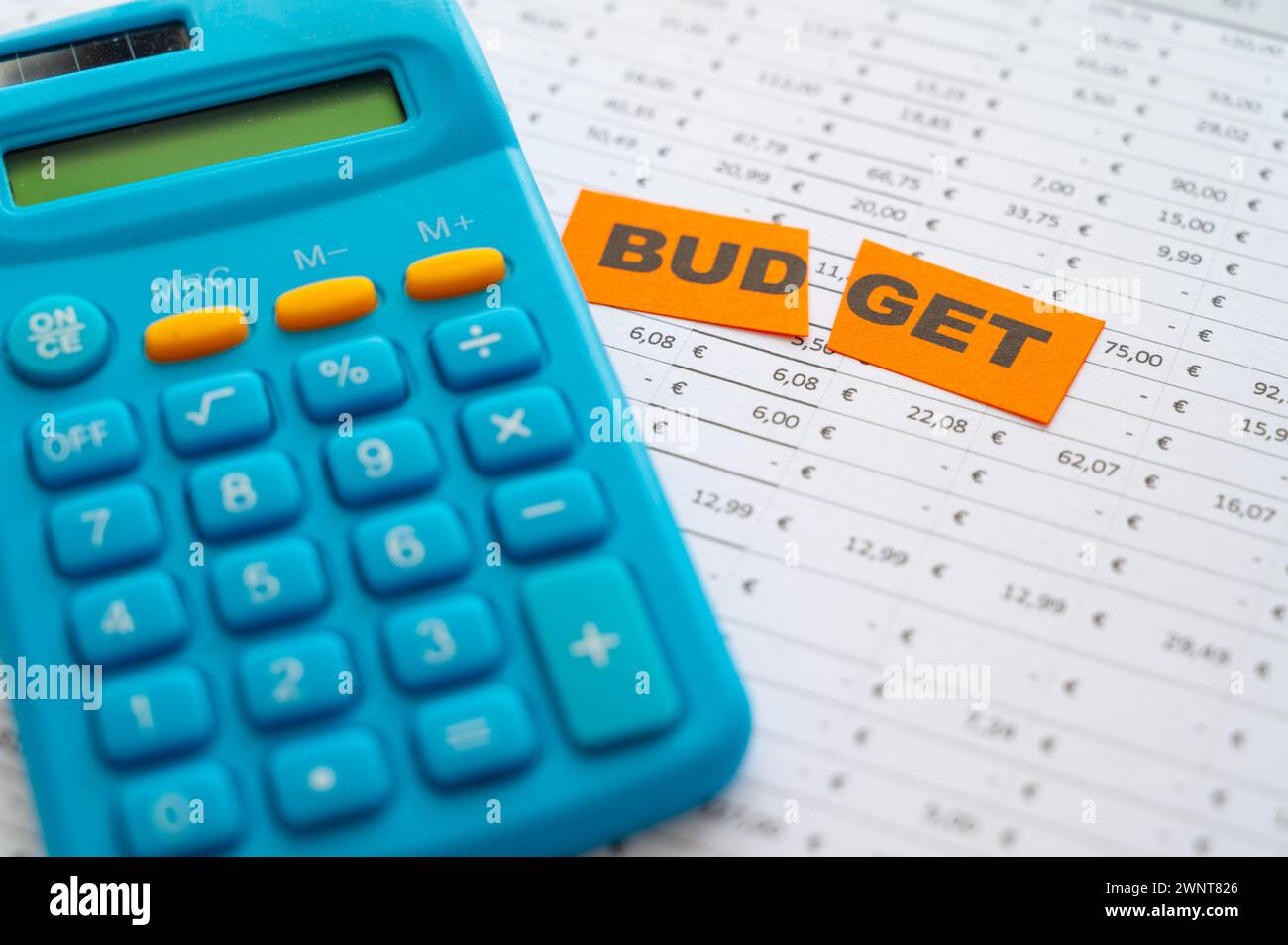 Calculator and coins above budget calculation table Stock Photo - Alamy