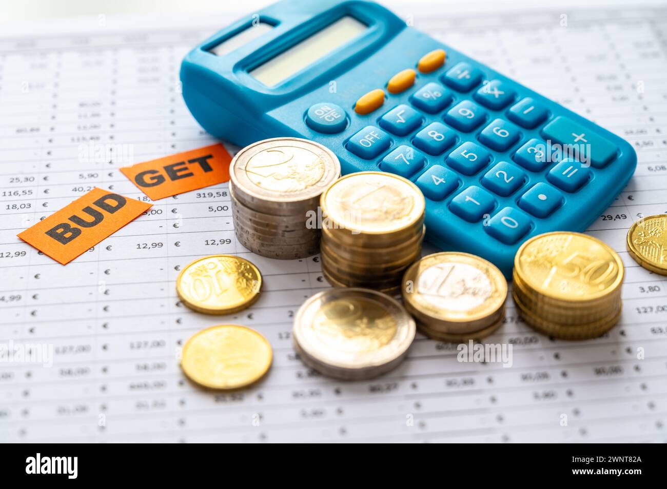 Calculator and coins above budget calculation table Stock Photo - Alamy