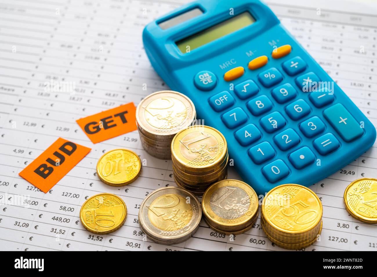 Calculator and coins above budget calculation table Stock Photo - Alamy