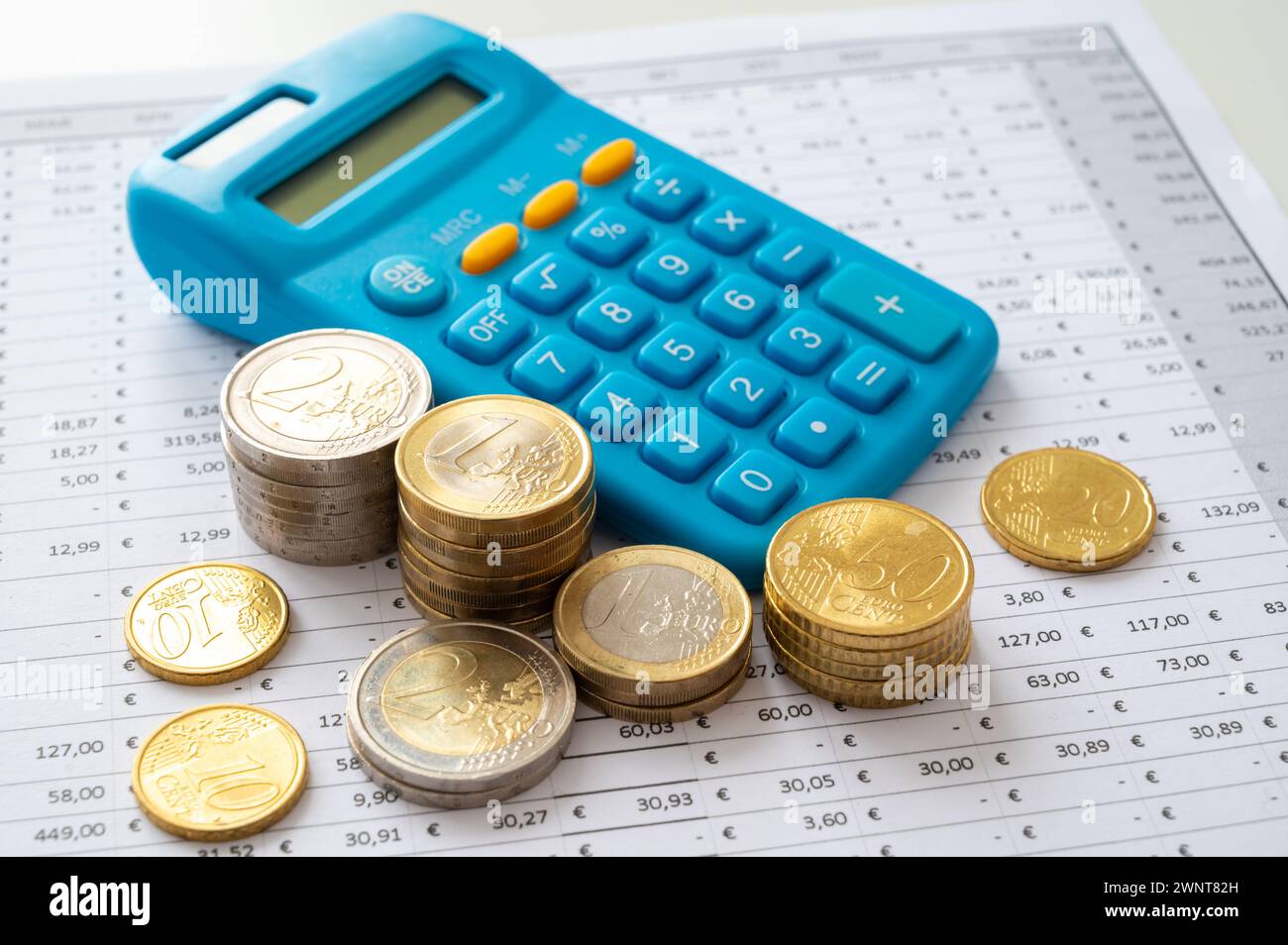 Calculator and coins above budget calculation table Stock Photo - Alamy