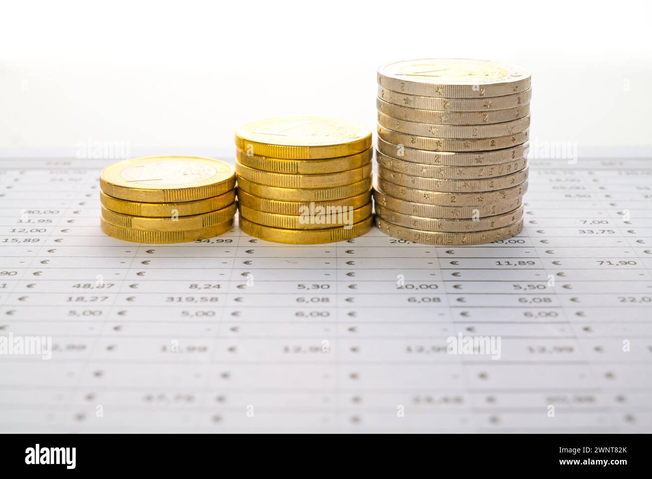 Table with calculations, budget, and stacks of coins; increase or ...