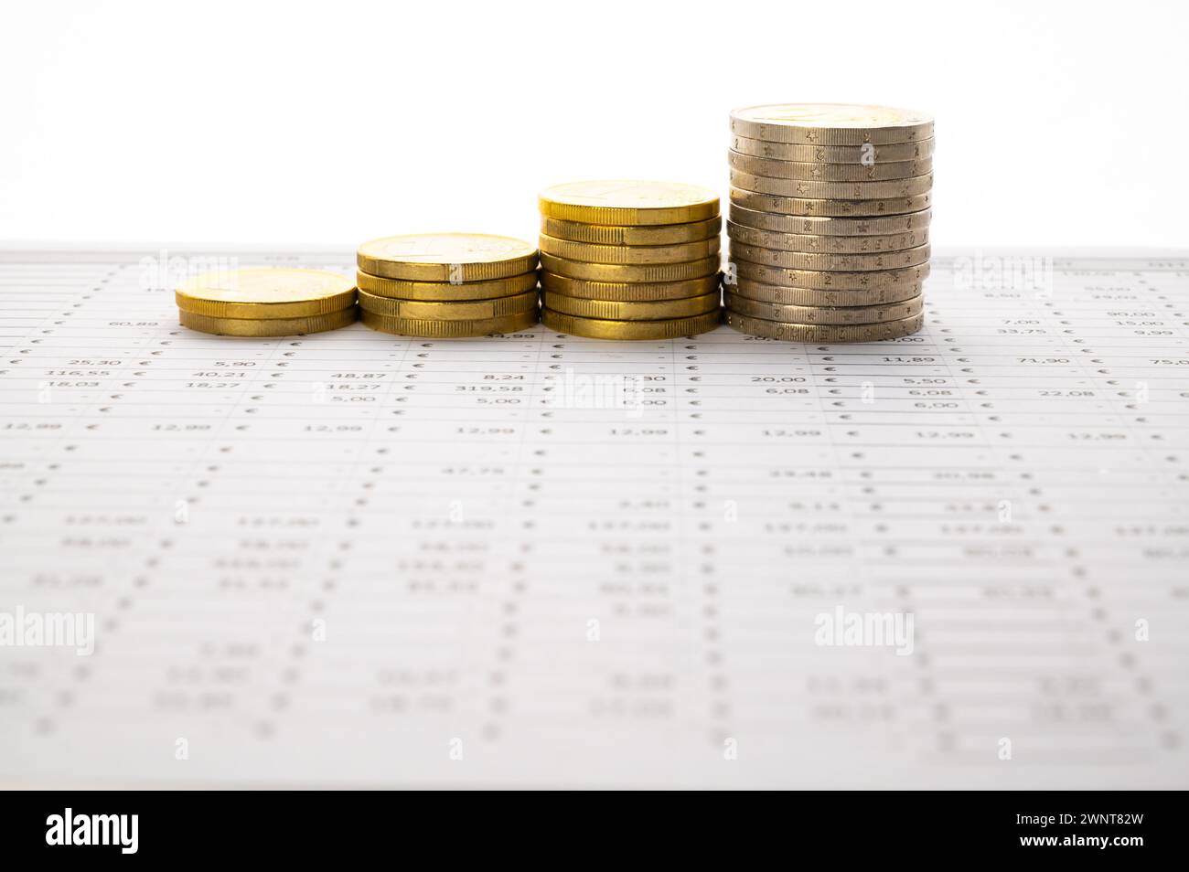 Table with calculations, budget, and stacks of coins; increase or decrease in money or budget ...