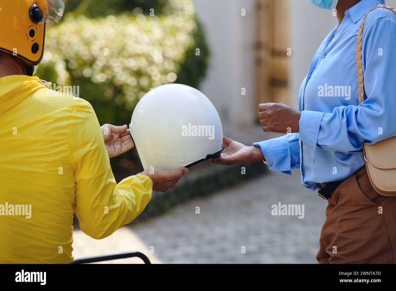 Motorbike taxi driver asking passenger to wear helmet for safety Stock ...