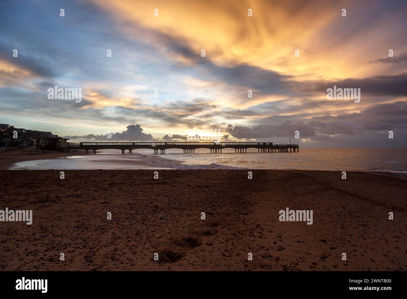 A view of the pier at Boscombe, Dorset, England at sunrise and low tide ...