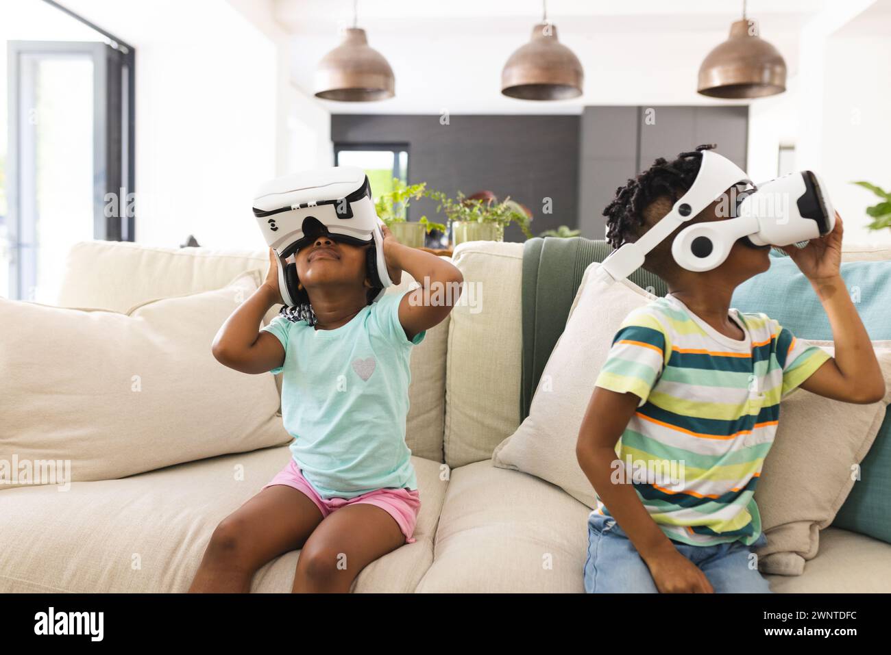 African American sister and brother are immersed in virtual reality ...