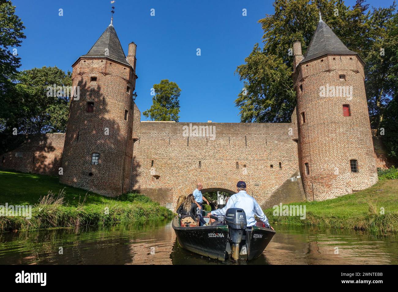 Tourists enjoying a boat ride on a moat in front of the old ...