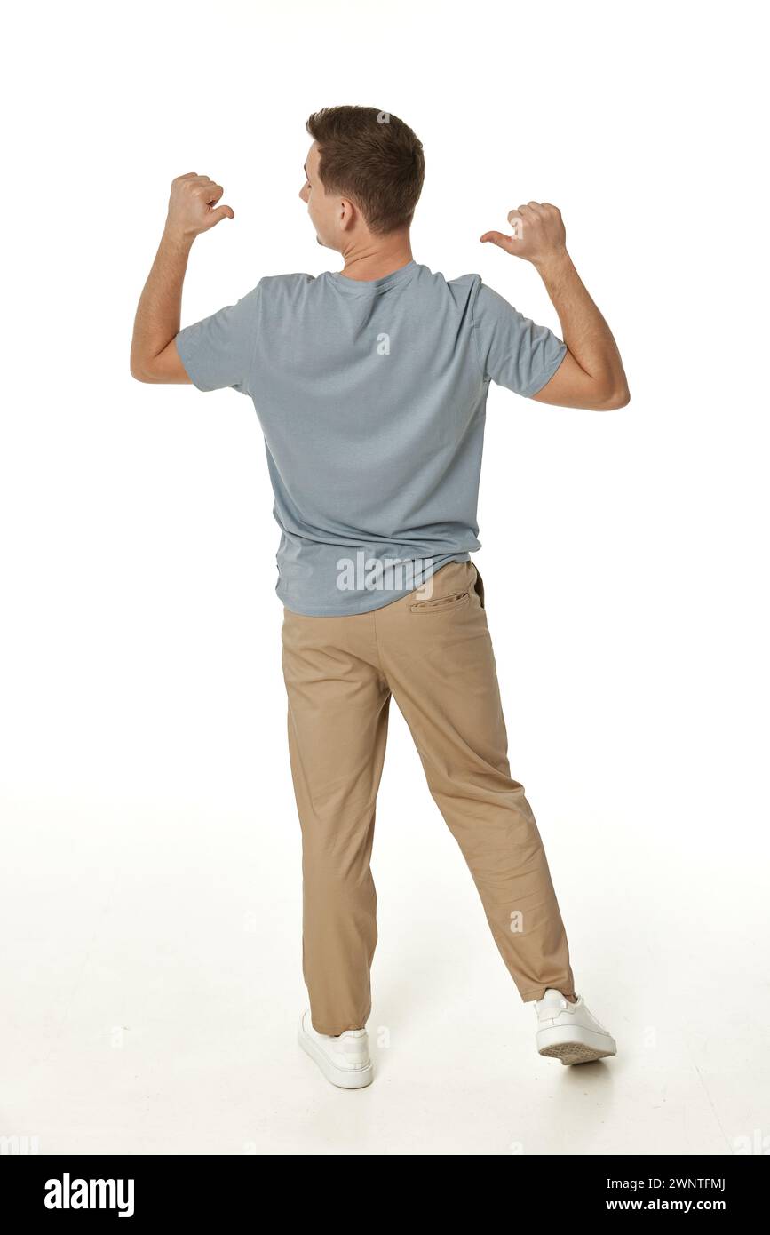 happy guy looking pointing to his back on white studio background Stock ...