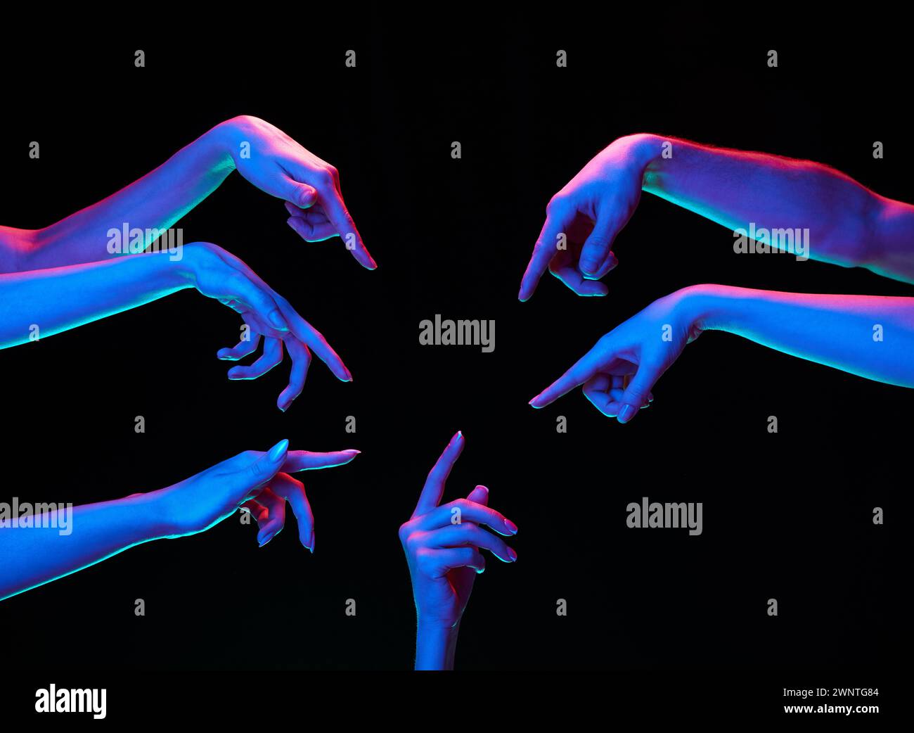 Hands in multicolored neon lighting with pointing gesture against black ...