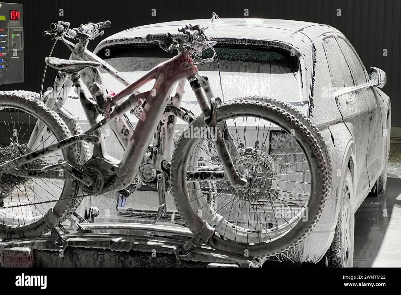Electric vehicle and bicycles at self-service car wash during nighttime ...
