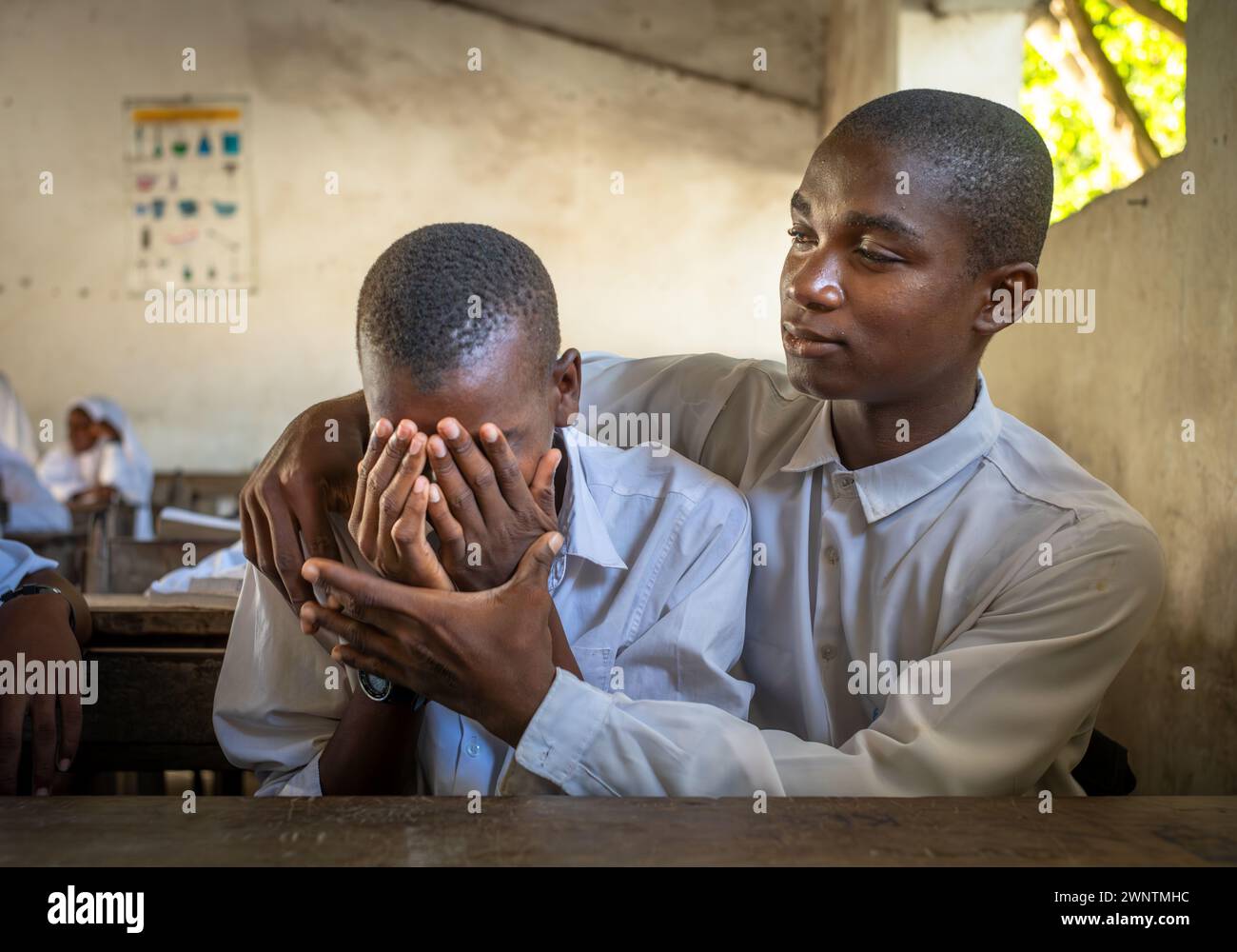 A Muslim boy student comforts his friend in an English class at ...