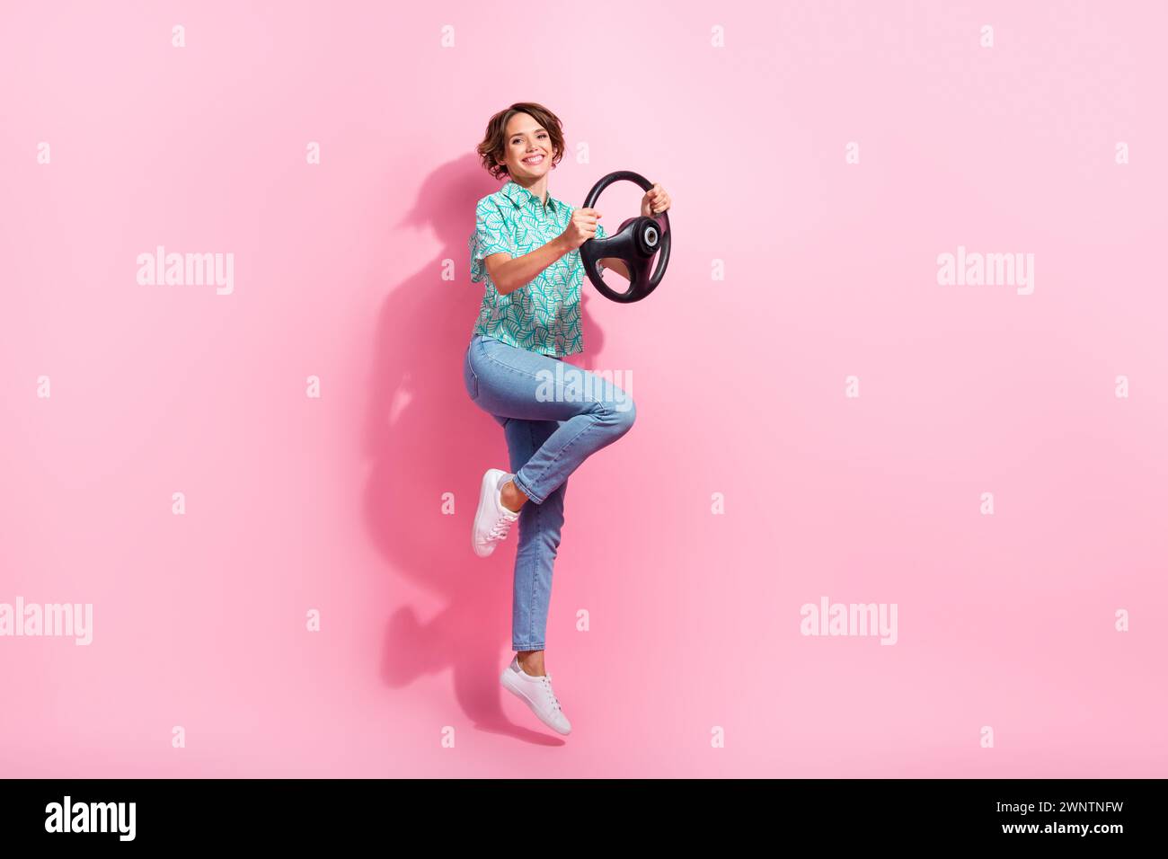 Full length profile photo of active cheerful person jump hold wheel ...