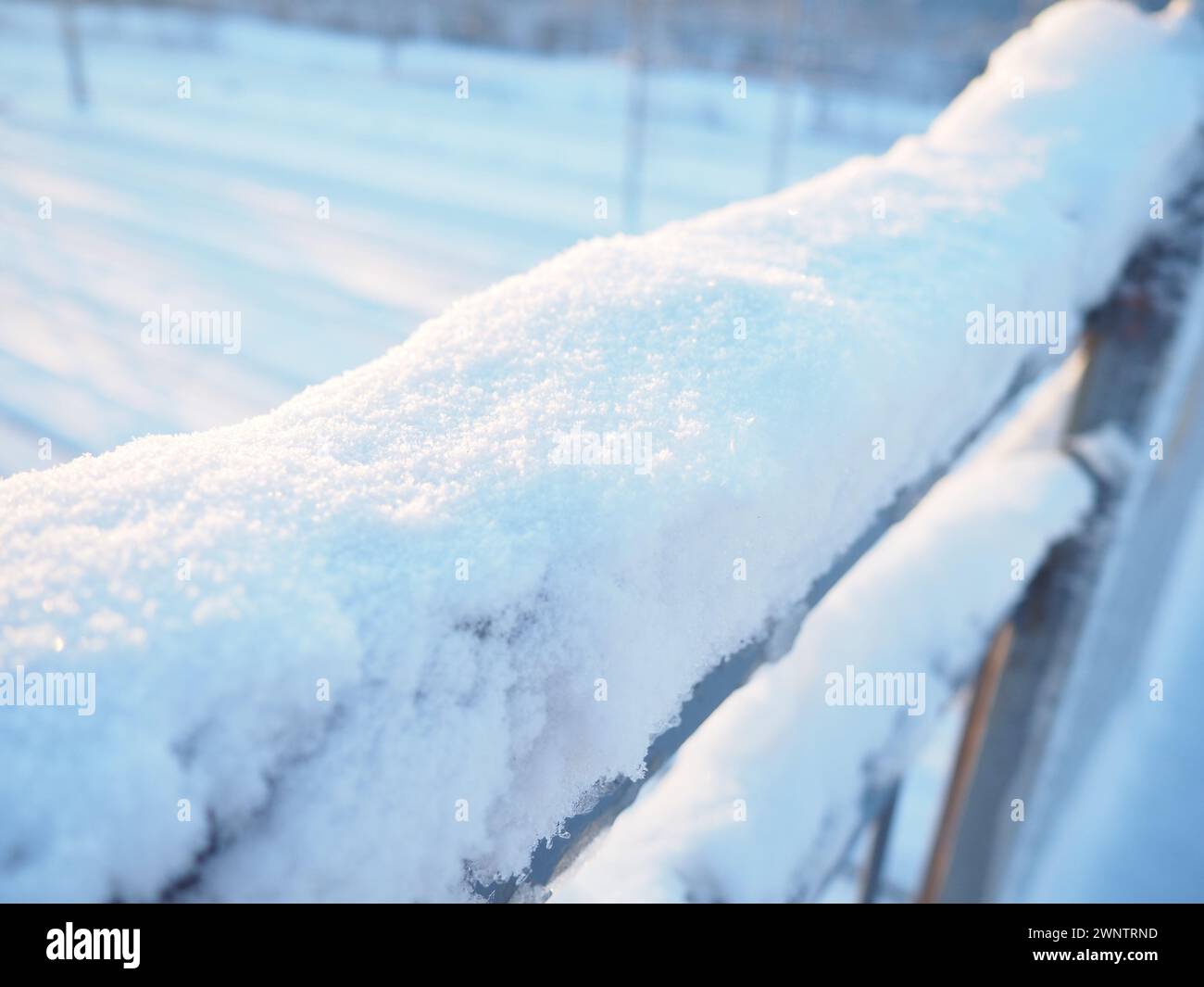 Snow, crust and frozen crust on metal railings. Suspension bridge over ...