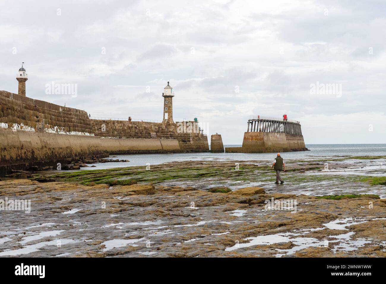 The tide out and Whitby East pier Stock Photo - Alamy