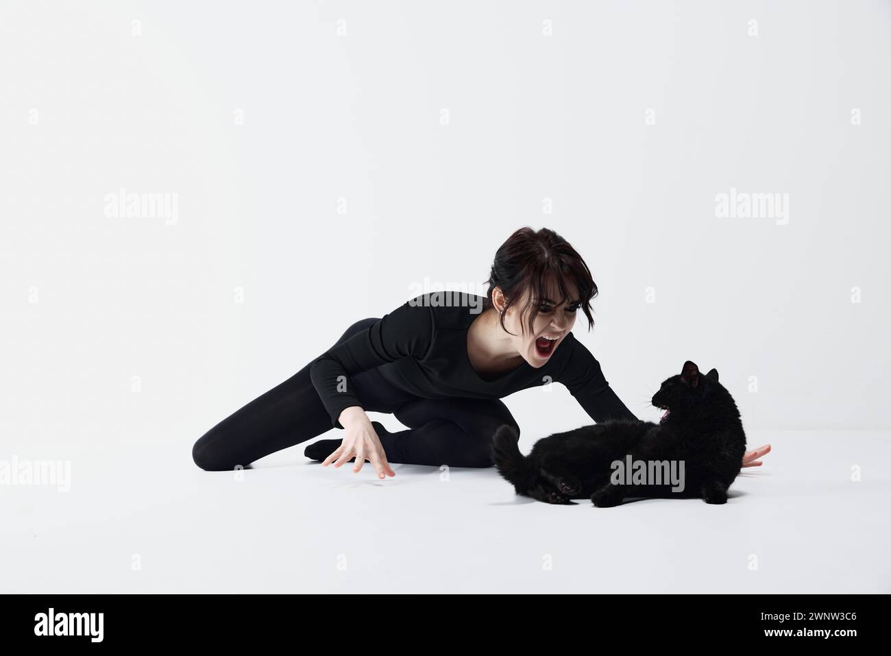 Artistic beautiful woman in emotional stance with black cat, both ...
