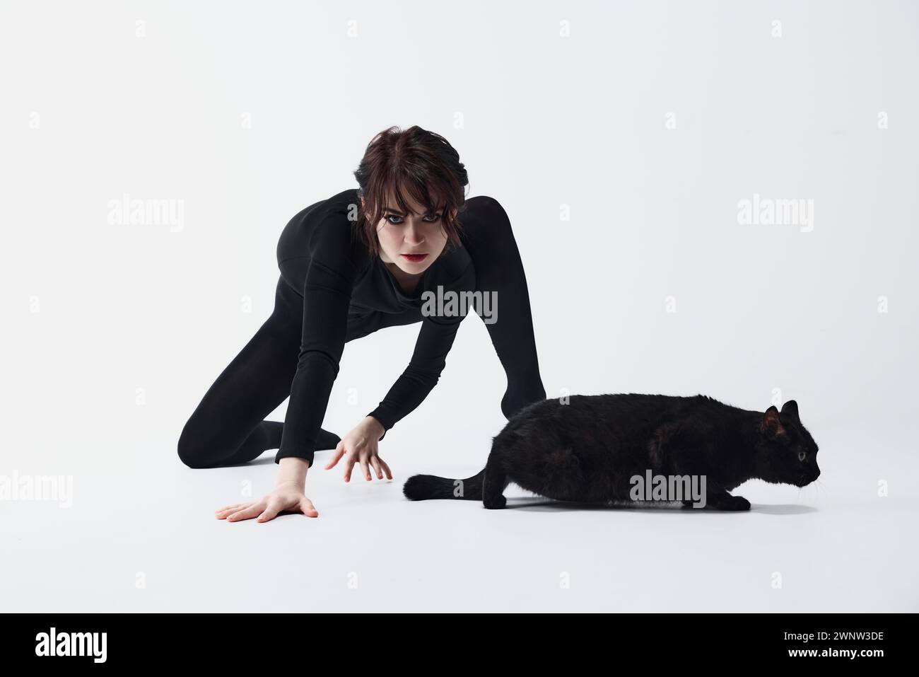 Focused woman with emotive face, smoky eyes makeup, in black clothes ...