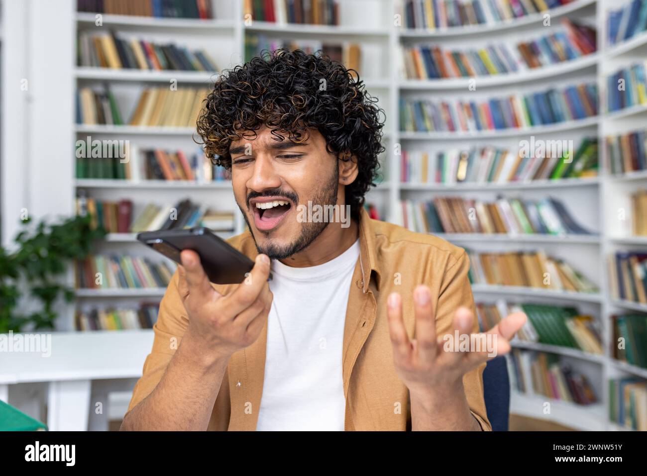 A young man with curly hair appears exasperated while having a heated ...