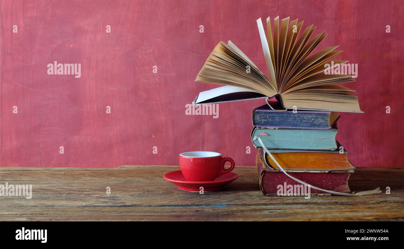 Stack of books with open book and cup of espresso coffee, reading ...