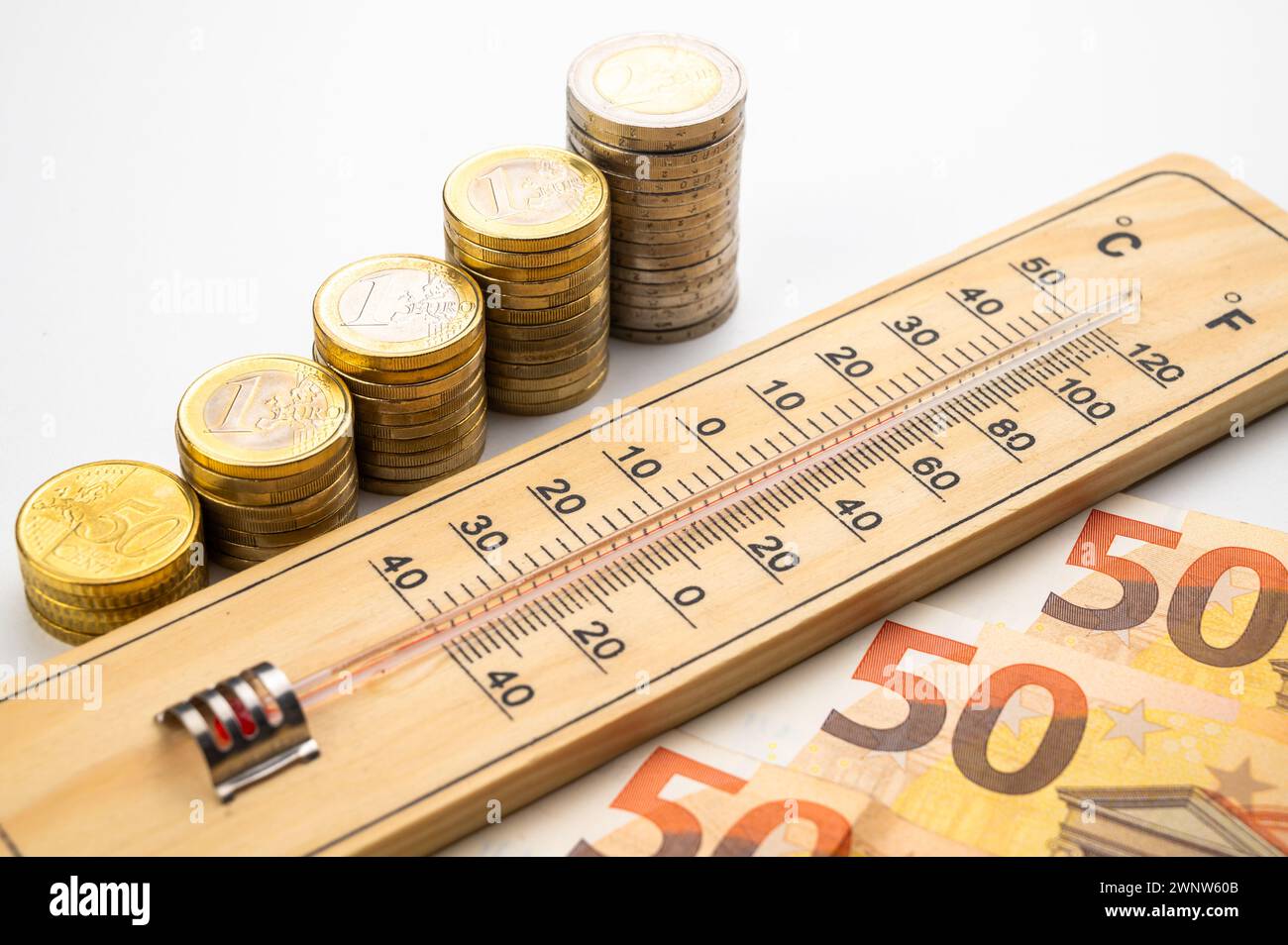 Room thermometer and stacks of coins and money. Space heating costs ...
