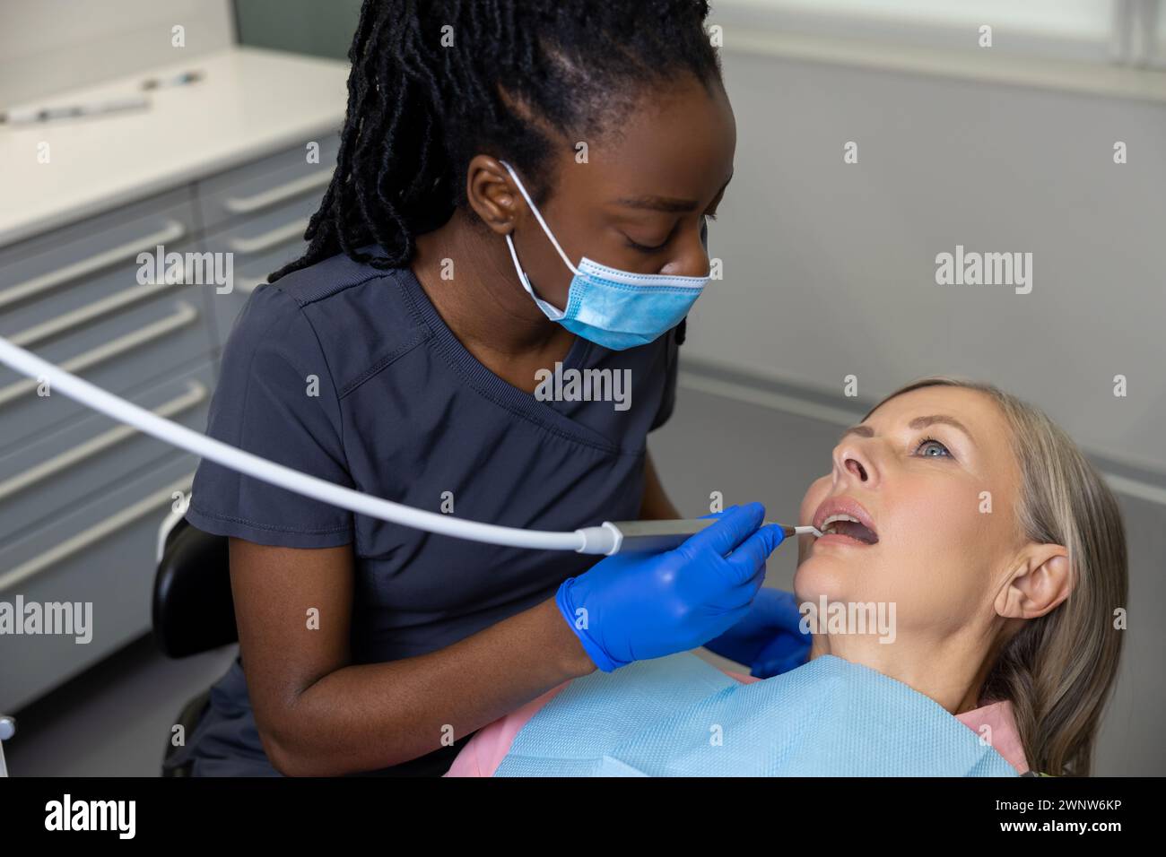 Woman patient sitting in dental chair at medical center while ...