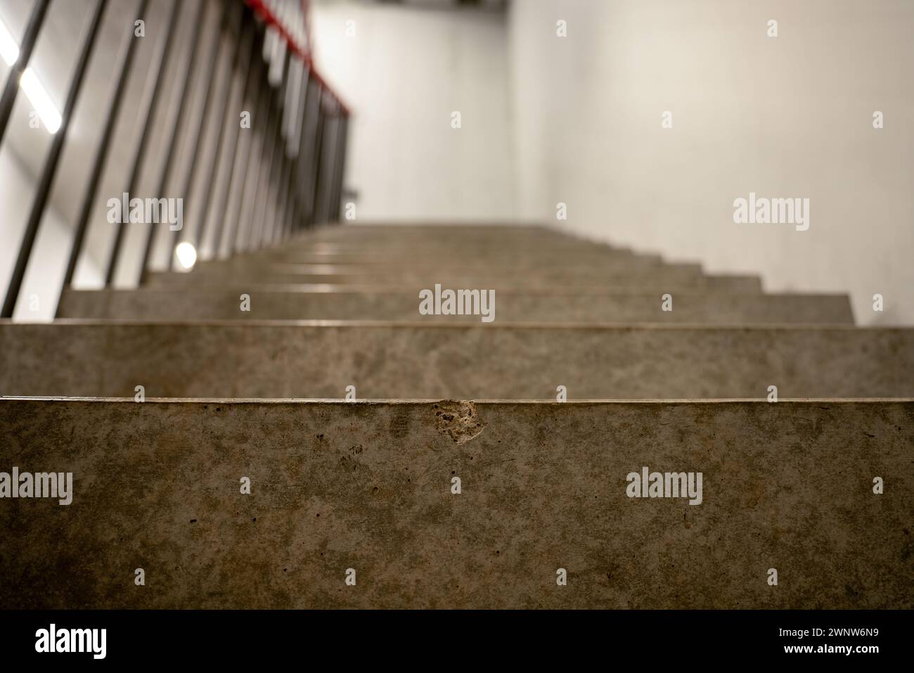 Looking up stairwell from below. Worm's eye view. Chipped off stair ...