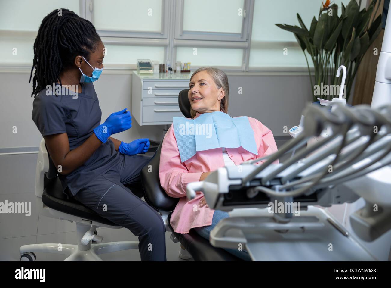 Woman patient sitting in dental chair at medical center while ...