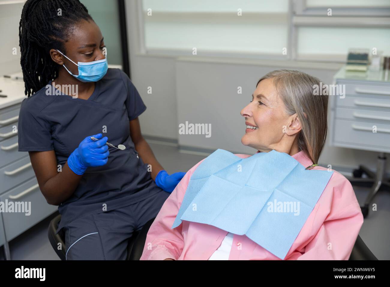 Woman patient sitting in dental chair at medical center while ...