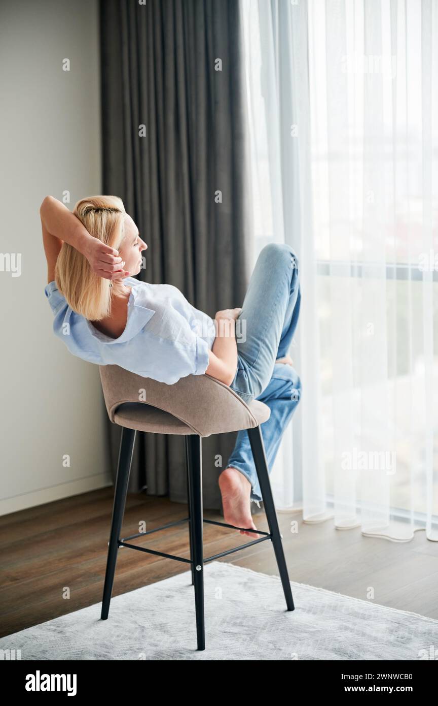 Back view of gorgeous woman relaxing on bar stool. Pretty female ...