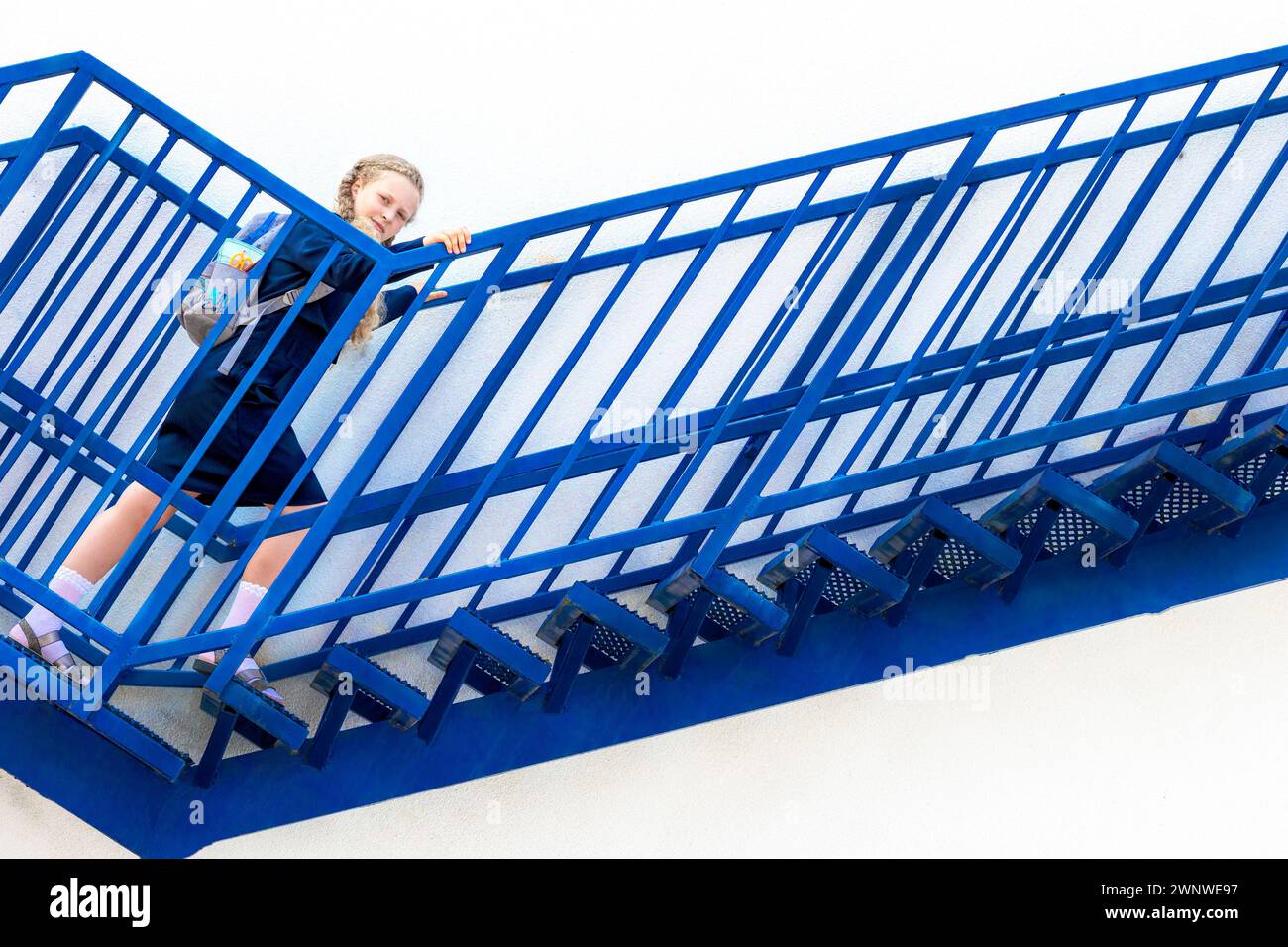 Schoolgirl with a smile climbs the stairs. Concept school days, start ...