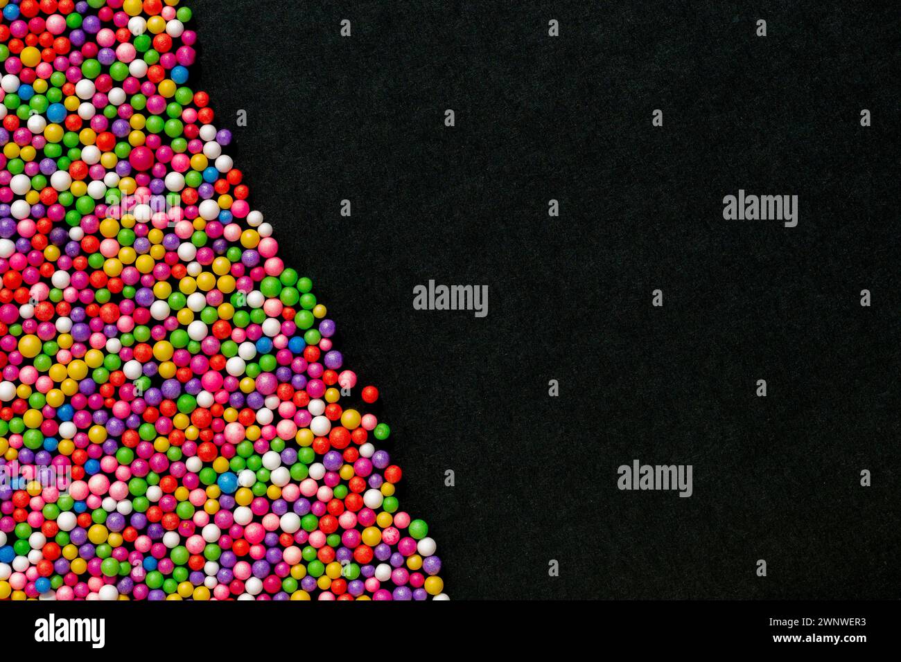 Dark, black background with colored balls. The texture is a lot of ...