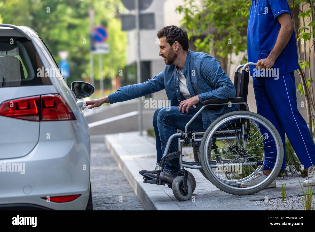 Man on a wheelchair getting into a car Stock Photo - Alamy