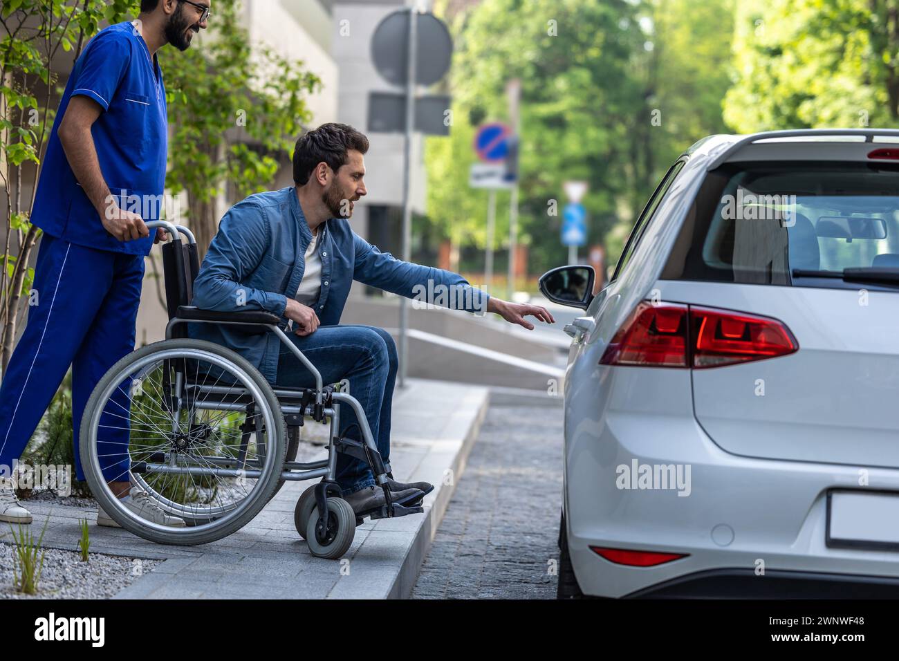 Man on a wheelchair getting into a car Stock Photo - Alamy