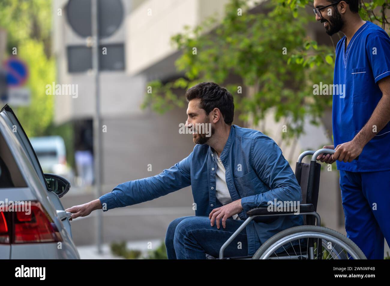 Man on a wheelchair getting into a car Stock Photo - Alamy