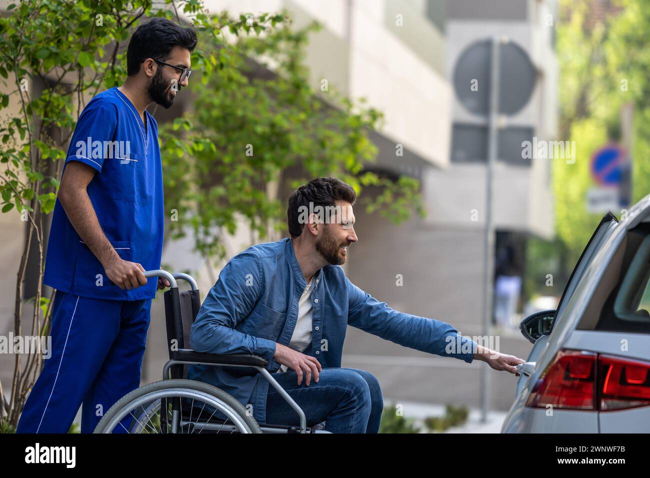 Man on a wheelchair getting into a car Stock Photo - Alamy