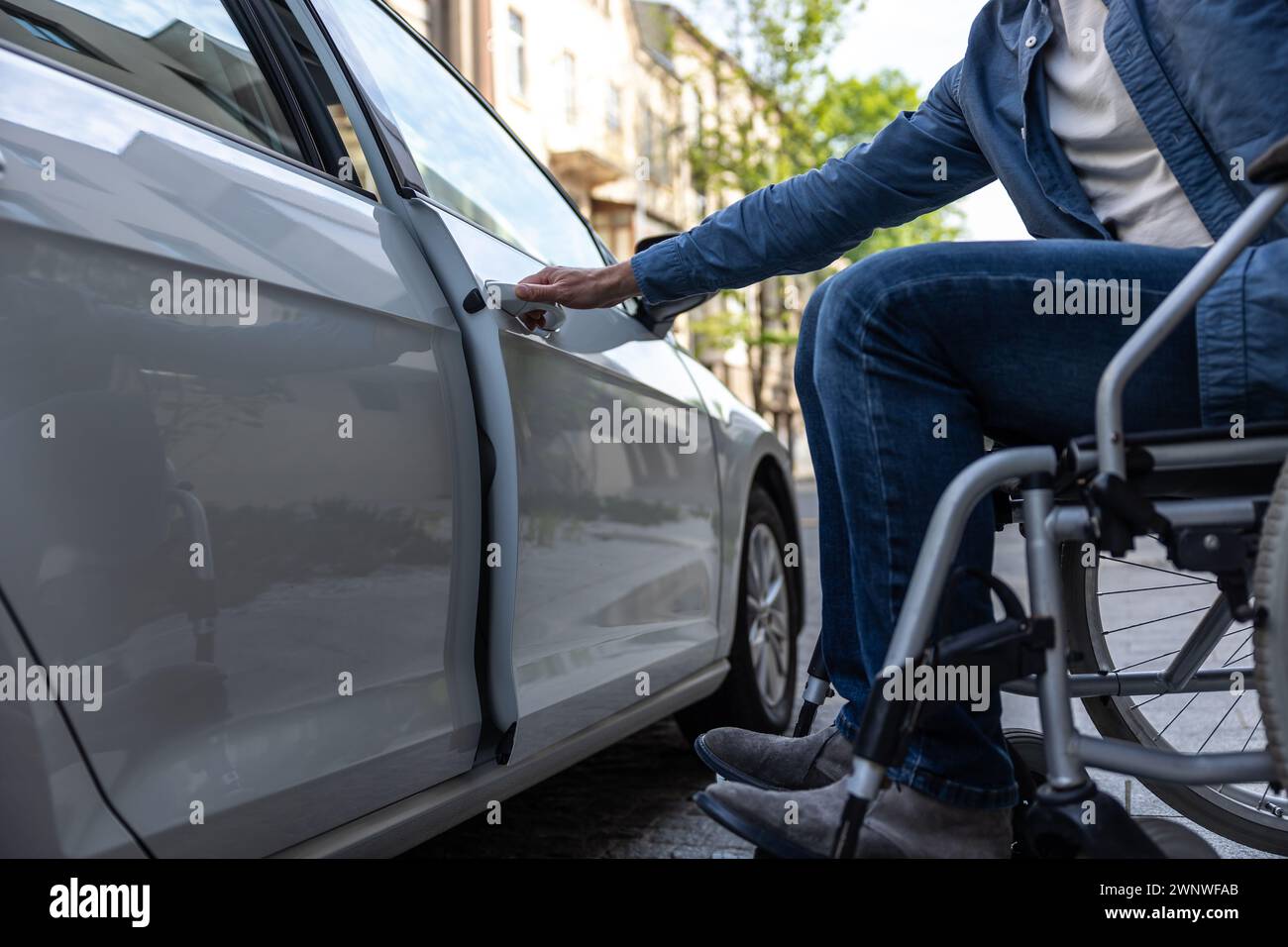 Disabled man in a wheelchair getting in a car Stock Photo - Alamy