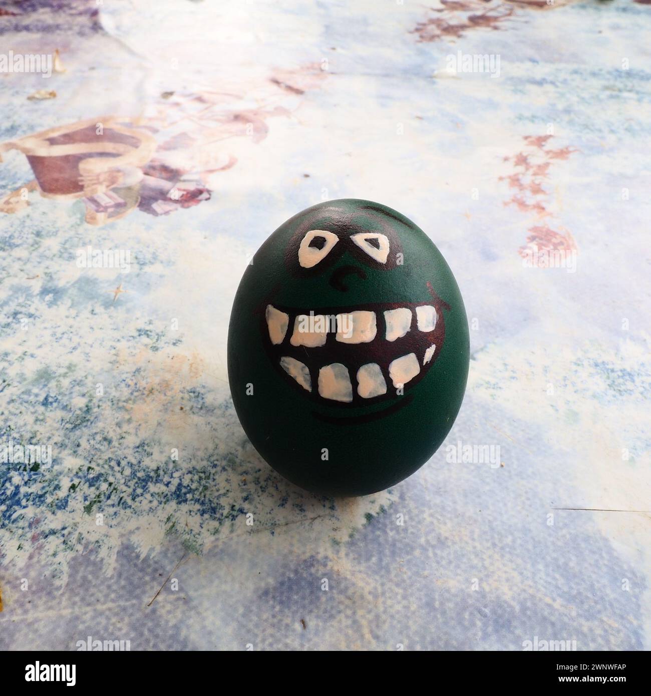 Easter egg dyed green with a painted laughing face. Cool grimace with ...