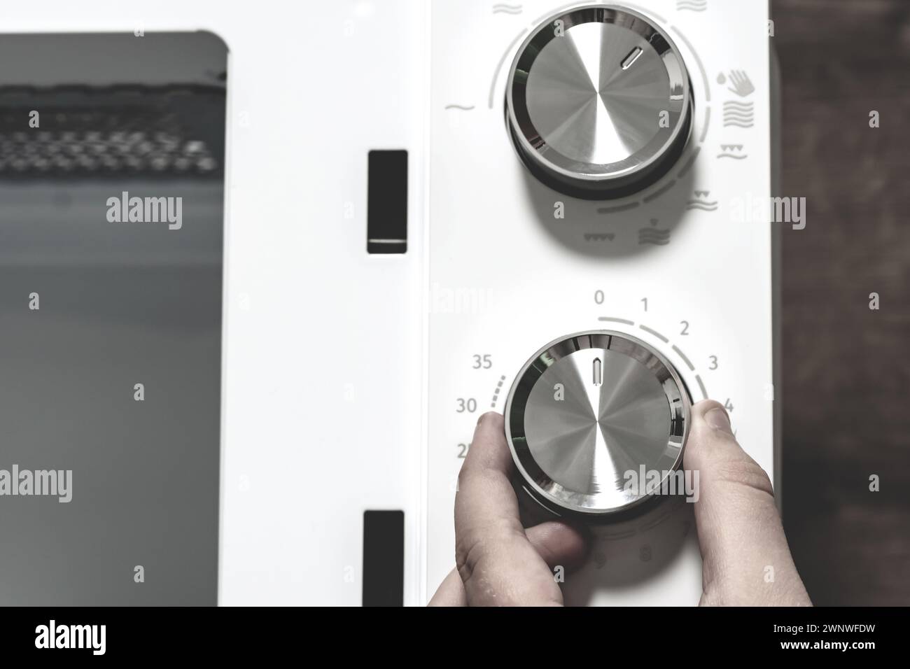 hand using an oven. Girl Adjusting Temperature Of Microwave Oven.Using ...