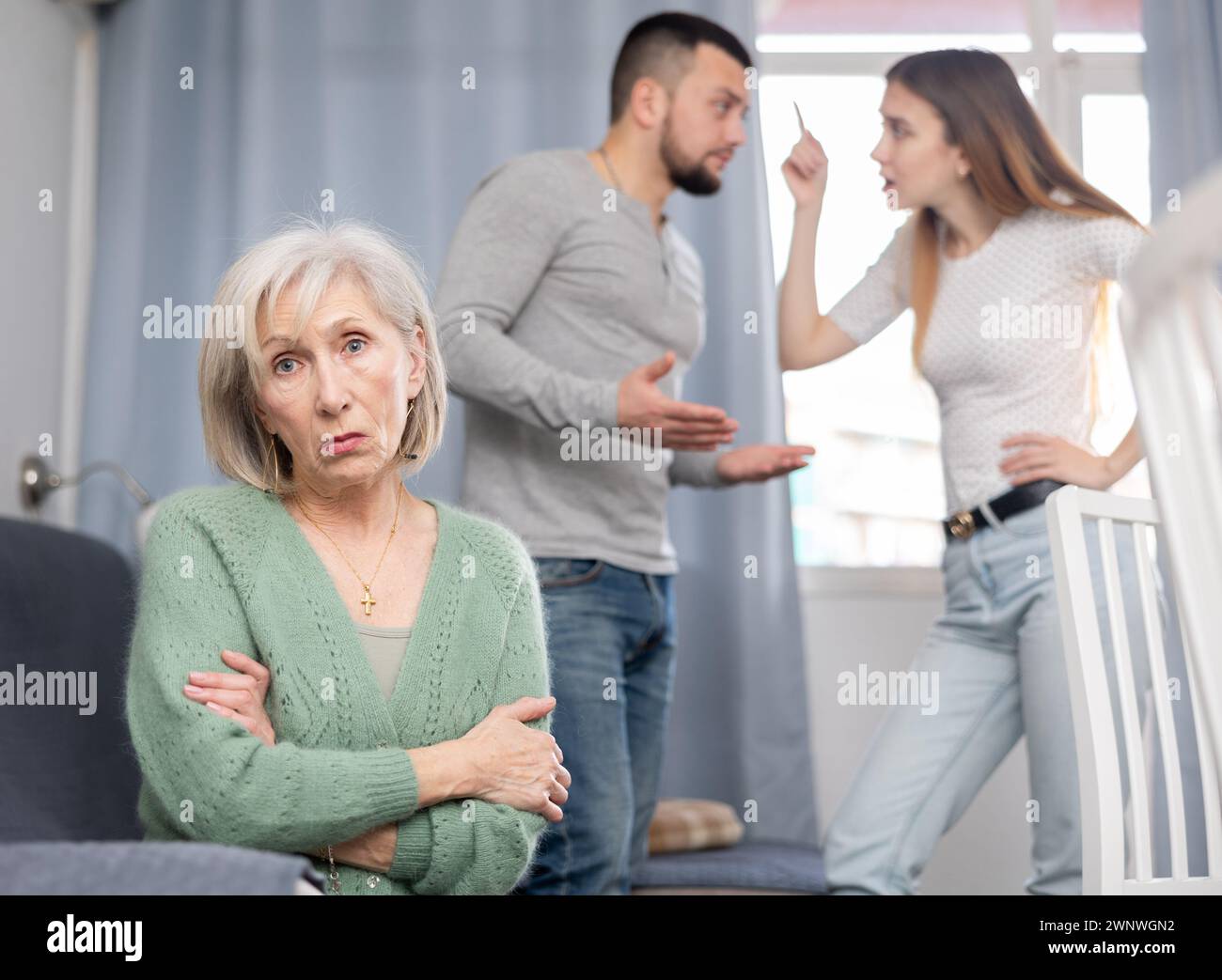 Old woman ignoring her daughter and son-in-law arguing with each other ...