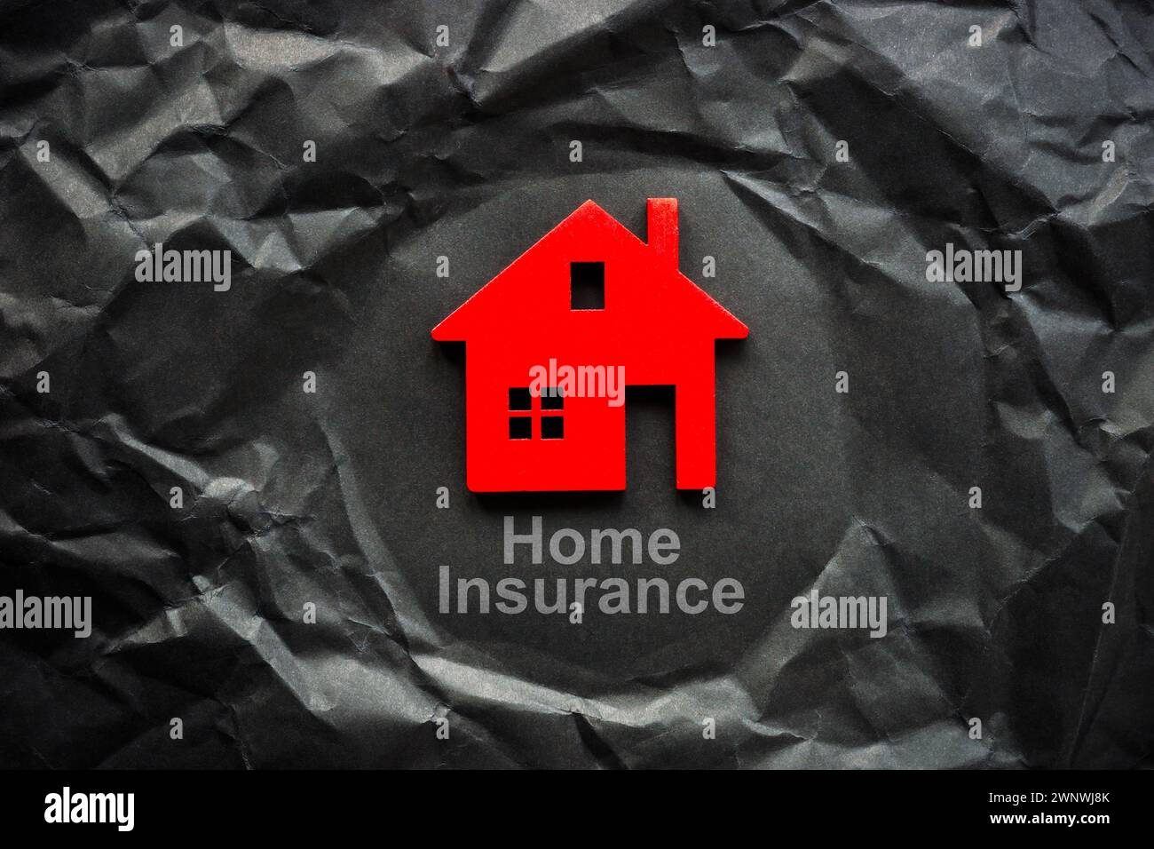 Home insurance concept. Model of a house on crumpled paper Stock Photo ...