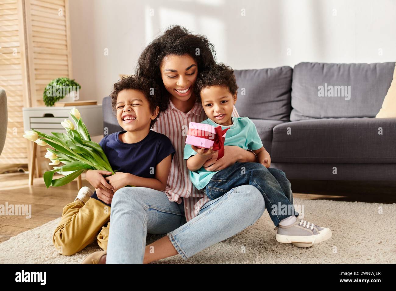 joyous african american woman receiving tulips and present from her ...