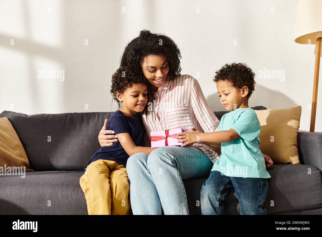 attractive merry african american woman receiving present from her two ...